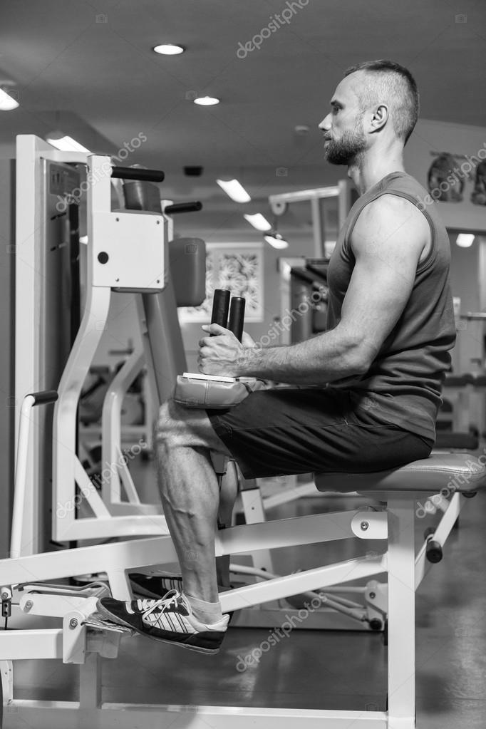 Man doing leg exercises, exercises on the simulator. Sports, healthy ...