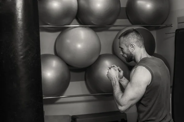 Muscular man in the gym. The man hit a punching bag, exercise. Boxing ...