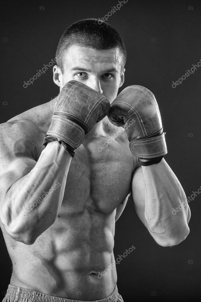 The man in boxing gloves. Young Boxer fighter over black background ...