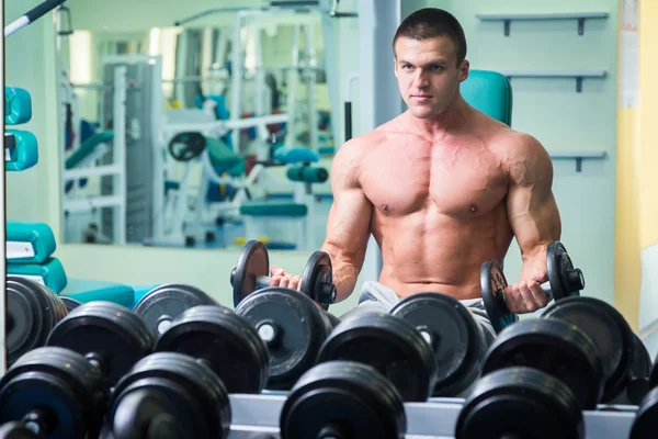 Muscular man working out with dumbbells - Stock Image - Everypixel
