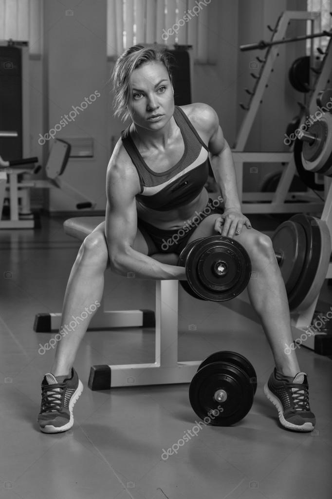 Beautiful girl takes exercises in the gym Stock Photo by ©aallm 90038094