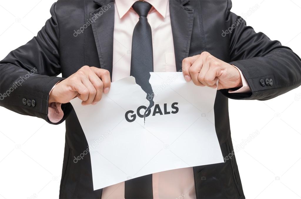 Empresario rompiendo el letrero de GOALS sobre fondo blanco 2024