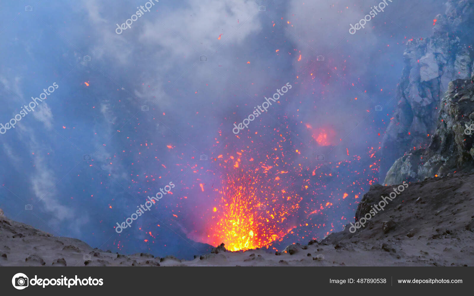 Mount Yasur exploding and belching out mist and hot pieces of glowing ...
