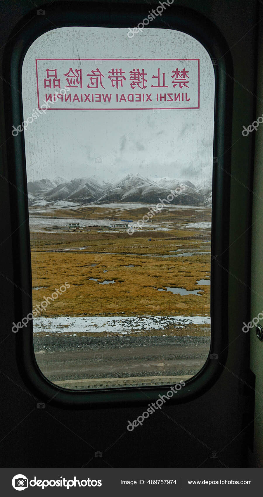 VERTICAL: Oval shaped train window offers a stunning view of the snowy ...