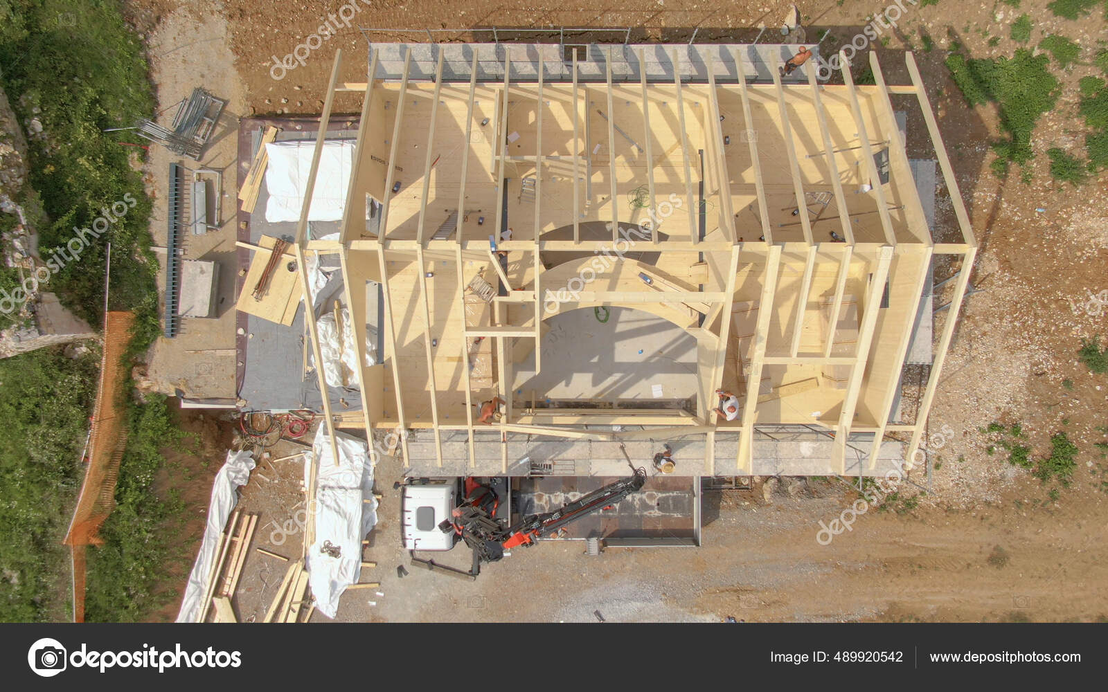 TOP DOWN Beams are lifted while workers assemble the roof of ...