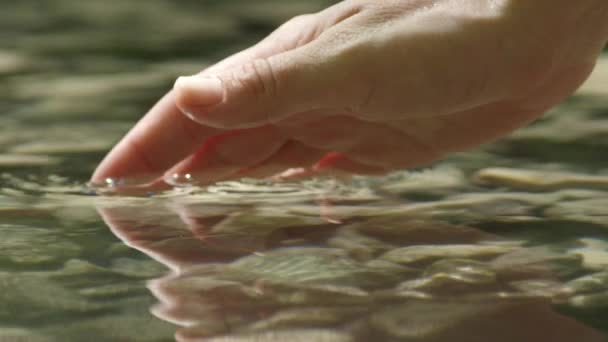 SLOW MOTION CLOSEUP: Hand grabbing and lifting crystal clear water ...