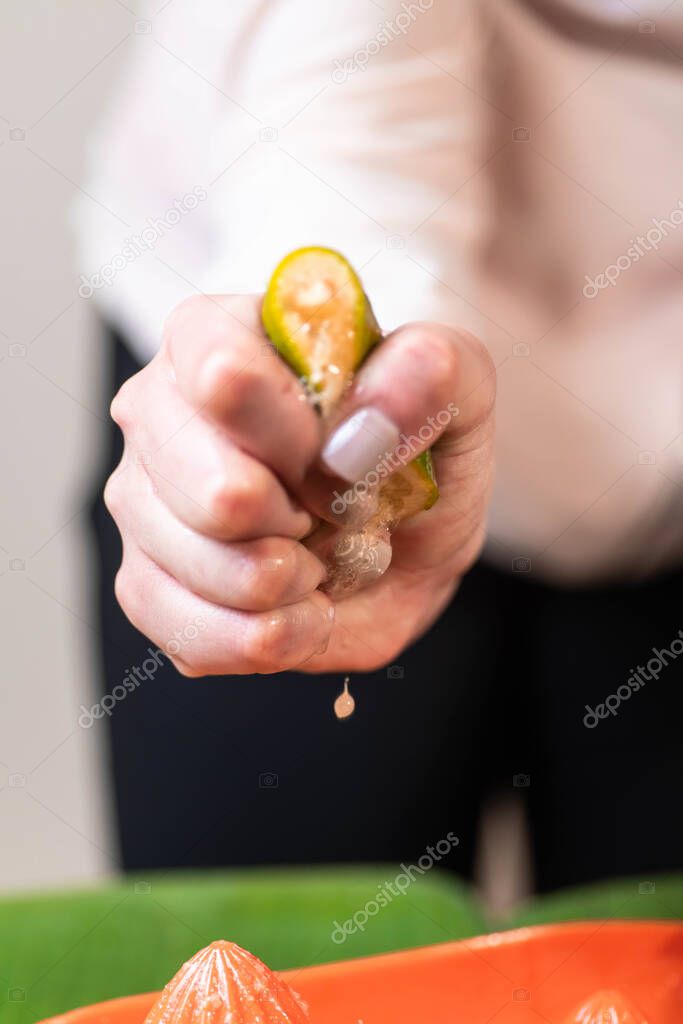 una toma vertical de la mano de la hembra exprimiendo una lima para ...