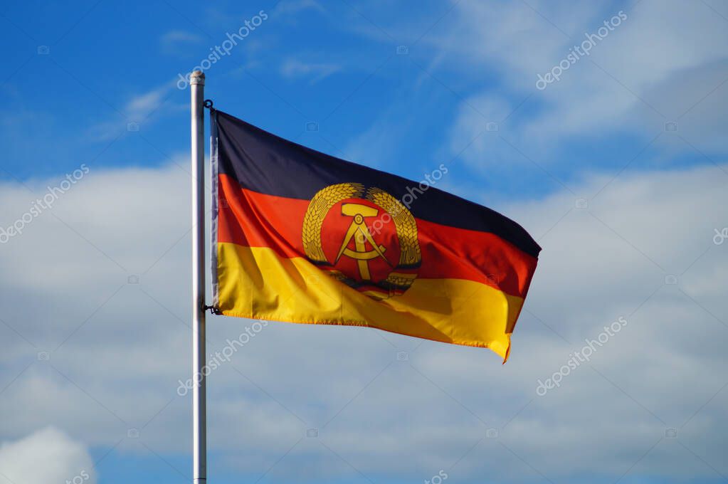 La bandera de la antigua RDA / Alemania Oriental ondea en un jardín de ...
