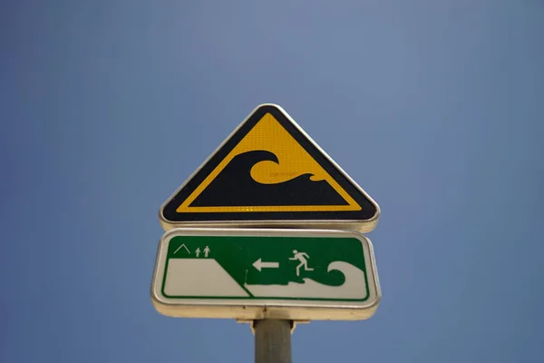 an emergency exit and wave warning road signs on blue backgound - Stock ...