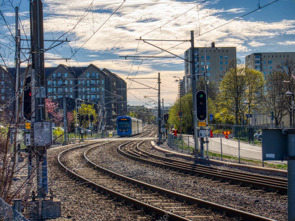 2 vías de tranvía paralelas con tranvía en la distancia y edificios de ...