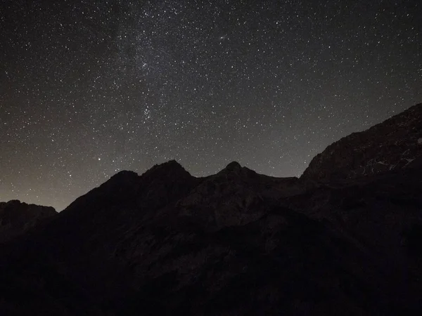 Dark black night sky panorama with stars milkyway over alpine mountain ...