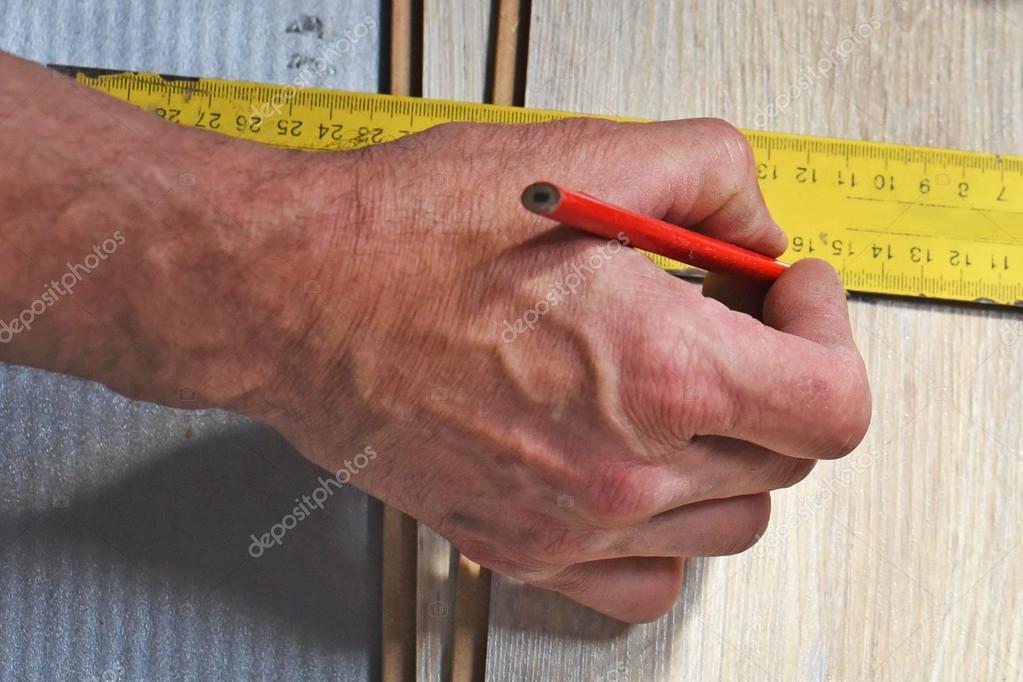 Hands of the carpenter measure closeup Stock Photo by ©nelyninell 78453034
