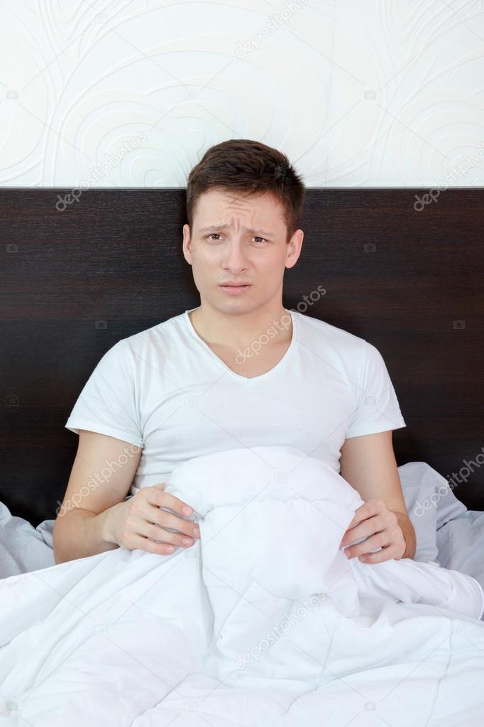Choqué beau jeune homme au lit regardant son pénis — Photo de stock par ...