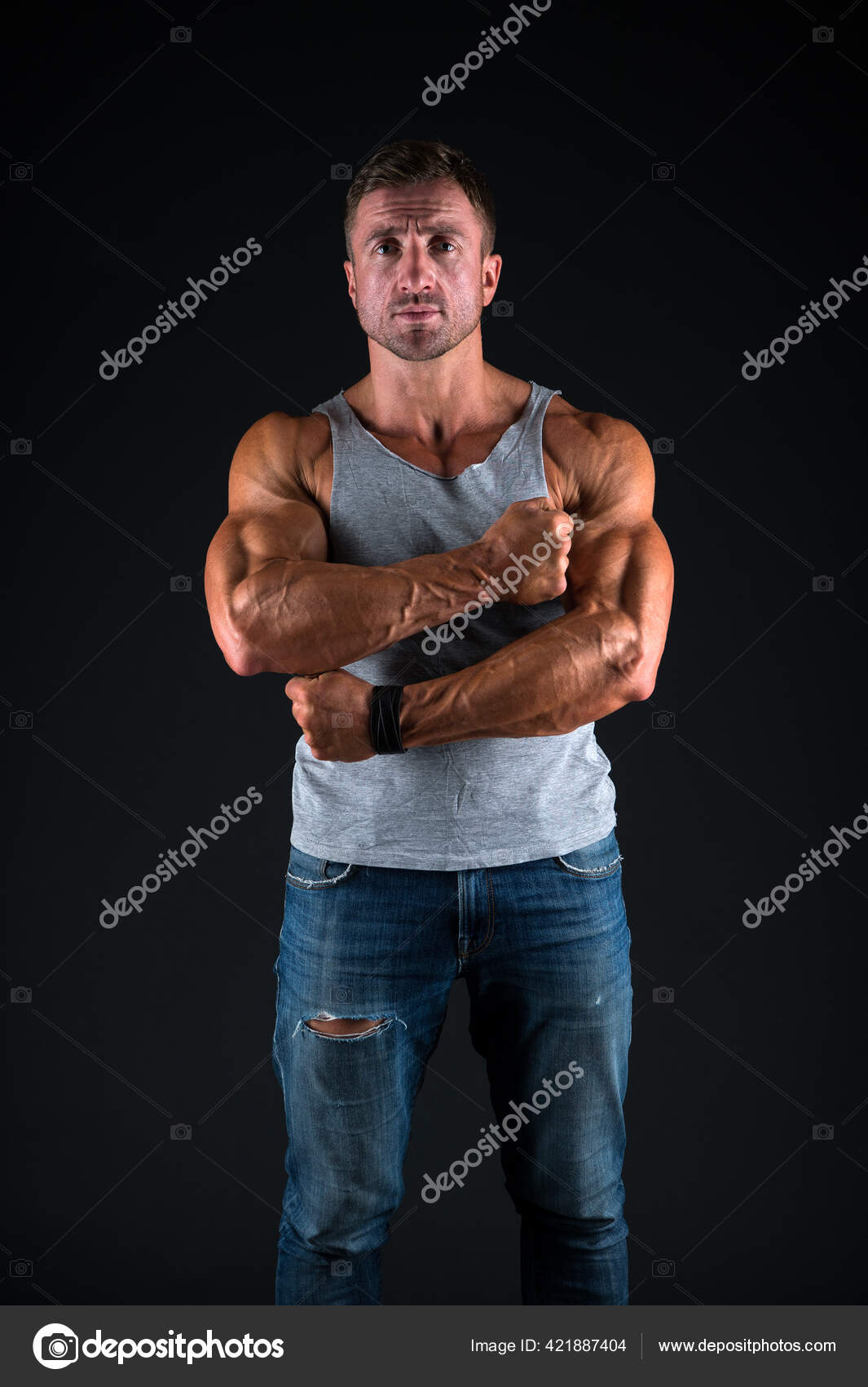 Athletic man cross strong muscular arms with biceps triceps muscles in ...