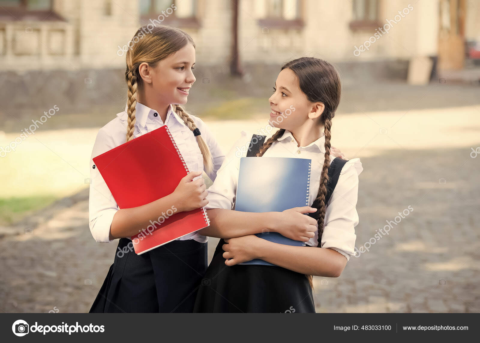 Primary and secondary schooling. Happy children hold books outdoors ...