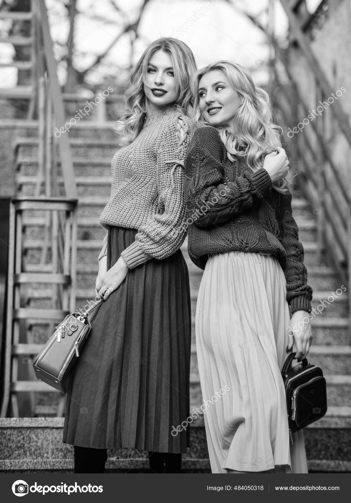Completing each other. Matching outfits. Women sisters outdoors stairs ...