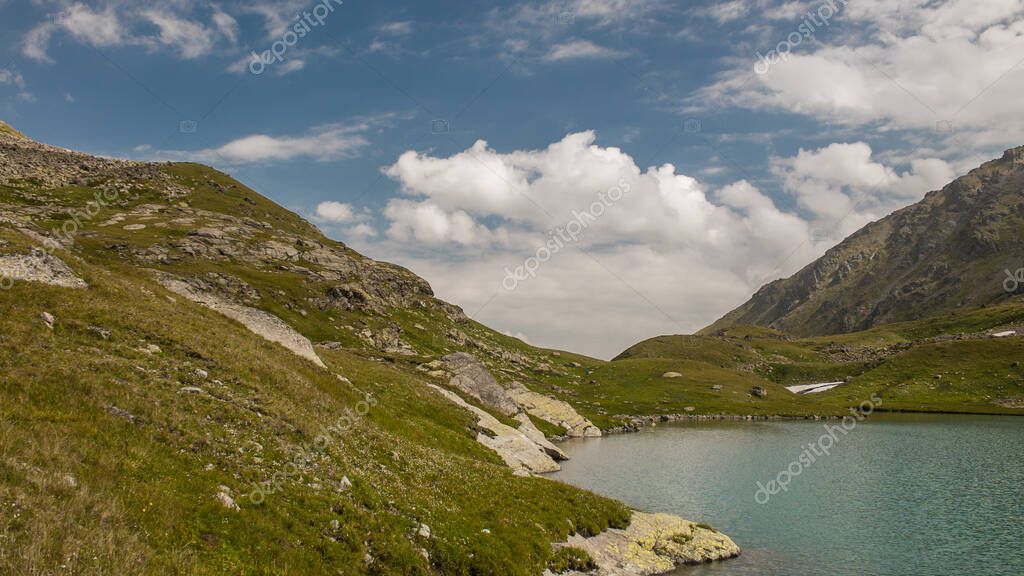 El paisaje alpino. Pasto verde en la ladera de la montaña. Cielo azul ...