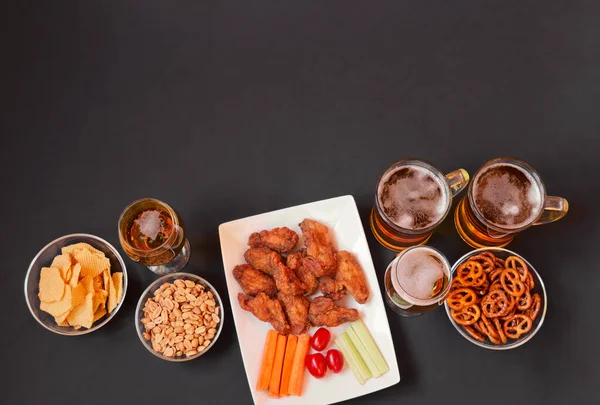 Border of glasses of beer, mugs of beer and beer snacks on dark ...