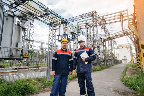Two specialist electrical substation engineers inspect modern high ...