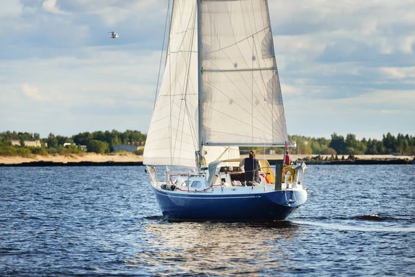 Blue sloop rigged yacht sailing in Riga bay at sunset, close-up. Baltic ...
