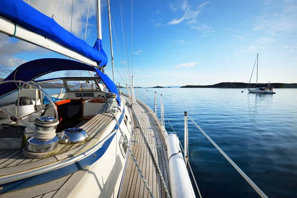 Sloop rigged modern yacht with wooden teak deck sailing near the shore ...