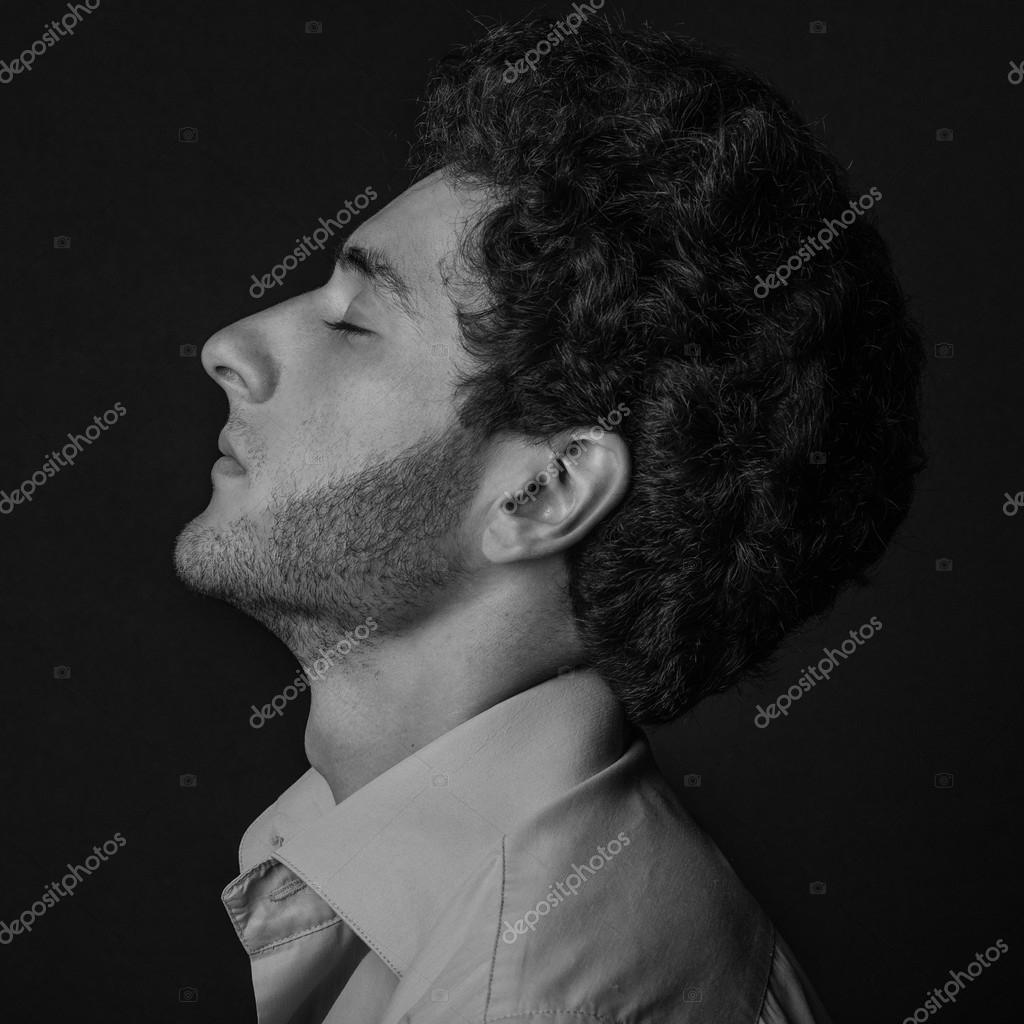 Dramatic portrait of a man theme: man sitting in profile wearing a ...