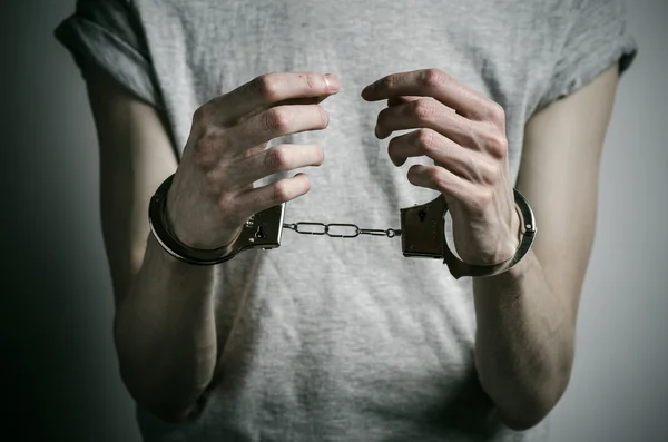 Prison and convicted topic: man with handcuffs on his hands in a gray T ... Prison and convicted topic: man with handcuffs on his hands in a gray T ...