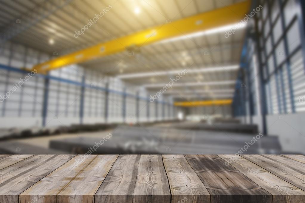 Wood table top on blur factory hall (or garage) background - can ...