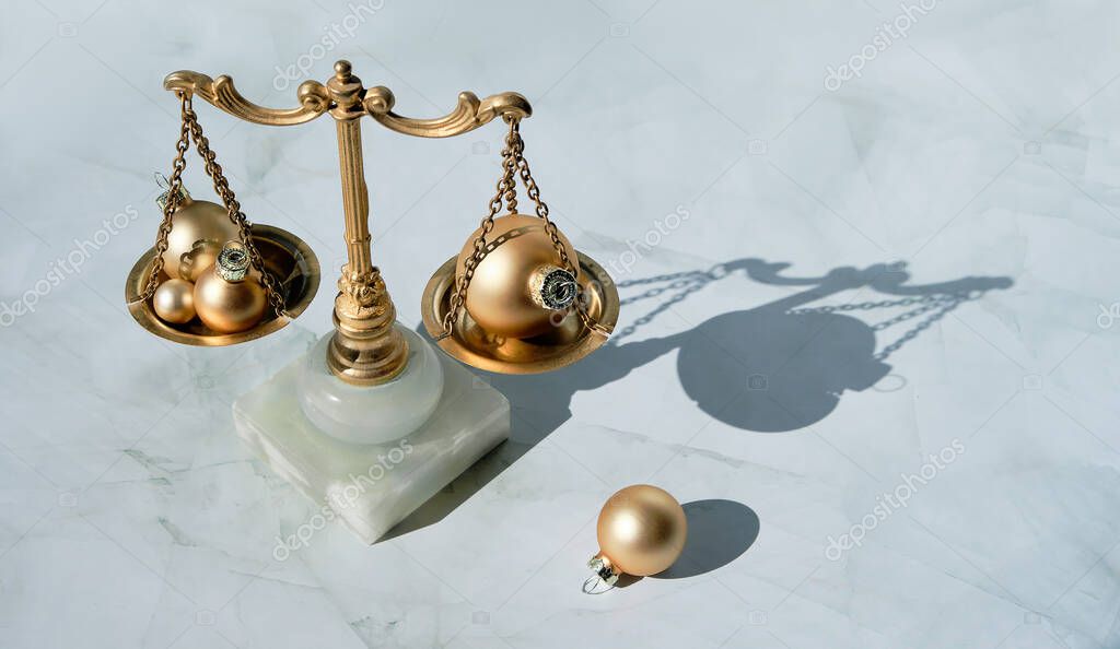 Primer plano de balanza decorativa de oro y mármol con bolas de Navidad ...