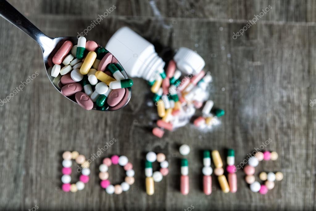 La palabra dopaje escrito con pastillas sobre un fondo de madera. 2024
