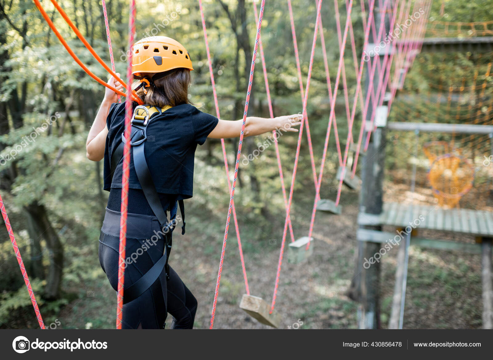 Woman climbing in a rope park — Stock Photo © rossandhelen #430856478