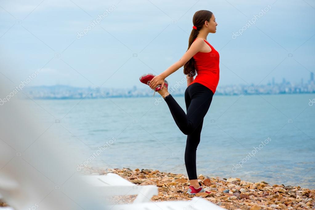 Woman having exercise on the beach Stock Photo by ©rossandhelen 74061617