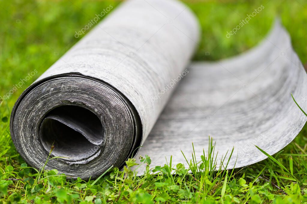 Rollo de techo se sintió de cerca. Ruberoid en la hierba verde. Una ...