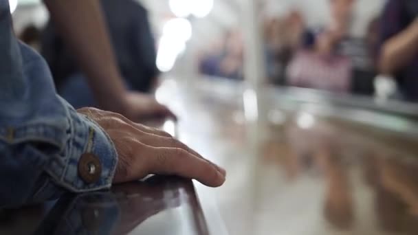 Mans hand moving fingers lifting on escalator in subway. Close up ...