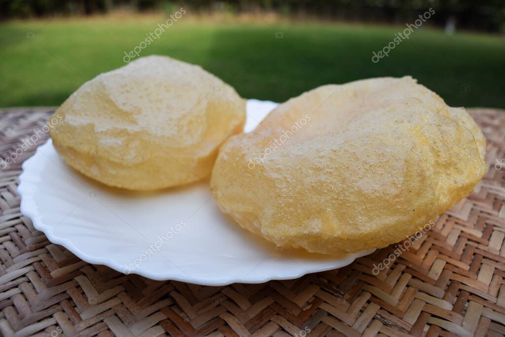 Puri liso o pan frito indio servido en plato blanco. Harina integral de ...