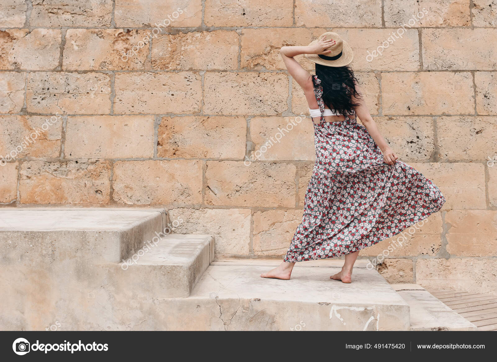 Beautiful barefoot brunette model with long dark hairs, straw hat and ...