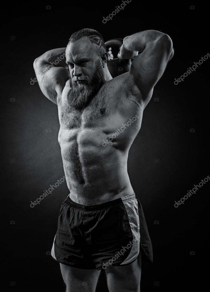 Bodybuilder with a beard lifts a heavy kettlebell Stock Photo by ...