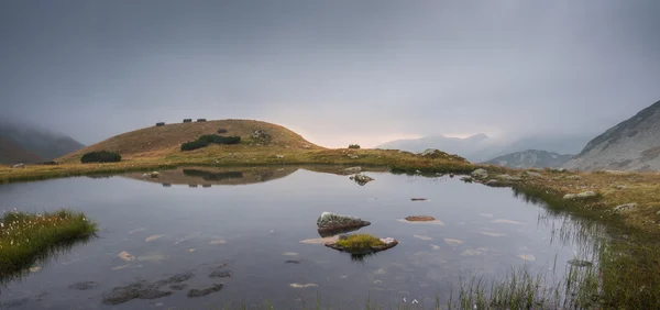 Small Tarn with Rocks in Foggy Mountains Stock Photo by ©Kayco 110983880