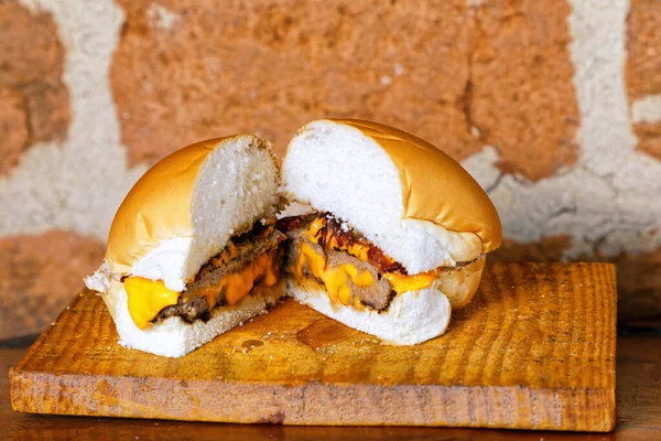Delicioso sándwich hecho a mano abierto por la mitad con hamburguesa ...
