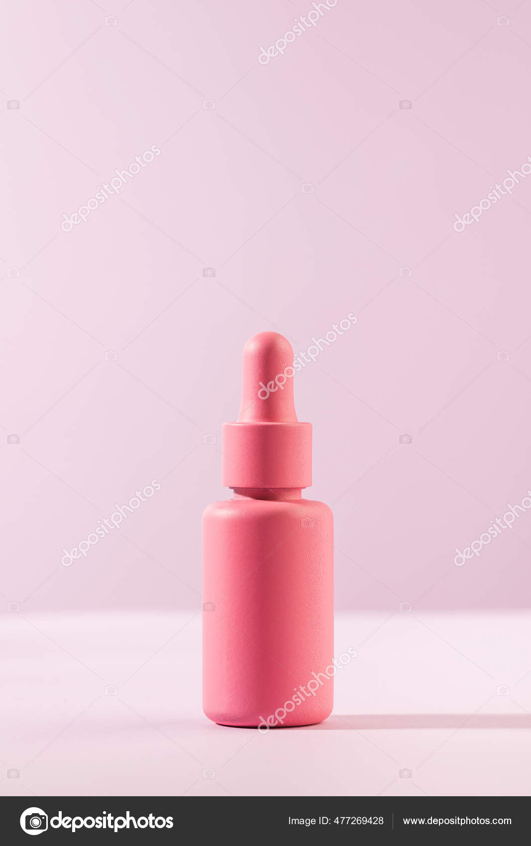 A mockup of a pink dropper with a facial serum on a pink background ...