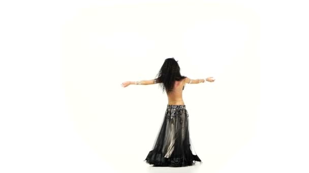 Belly dancer with dark hair shaking her hips, on white, slow motion ...
