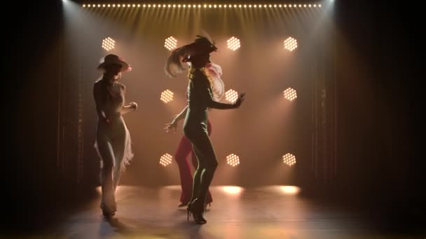 A theatrical performance of three slender graceful ladies in chic stage ...