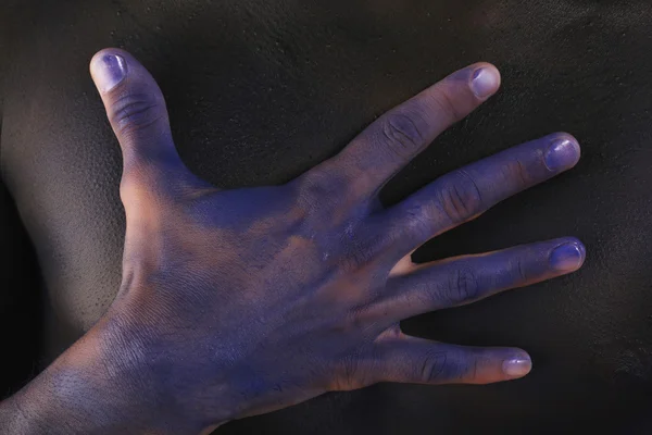 Body art tinted black man's hands on the background of male body ...