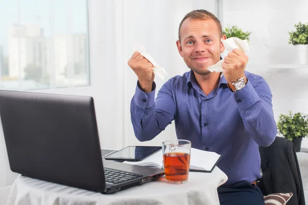 Young businessman working in the office, very concerned, a panic ...