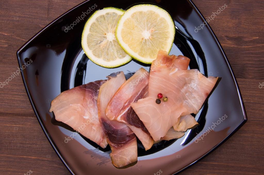 Smoked swordfish on black plate on wood from above and close Stock ...