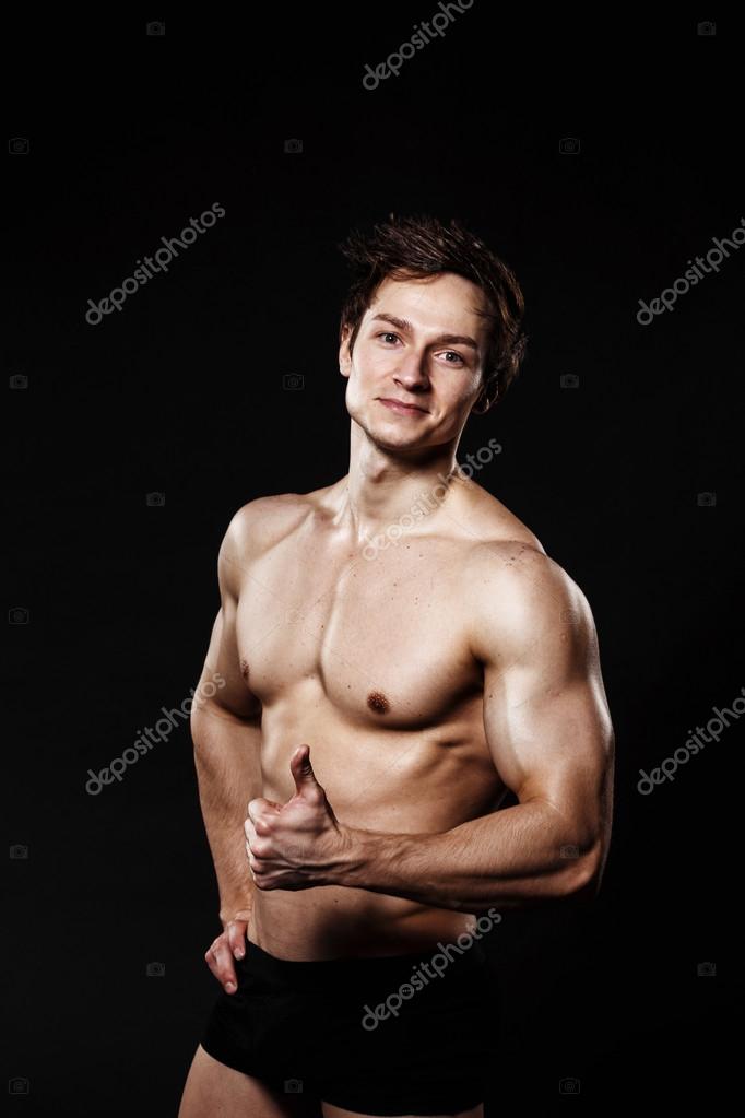 Handsome athletic man showing thumb-up in black pants. Strong bo Stock ...