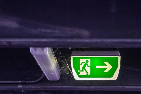 Green exit sign with running person and green arrow shows guidance ...