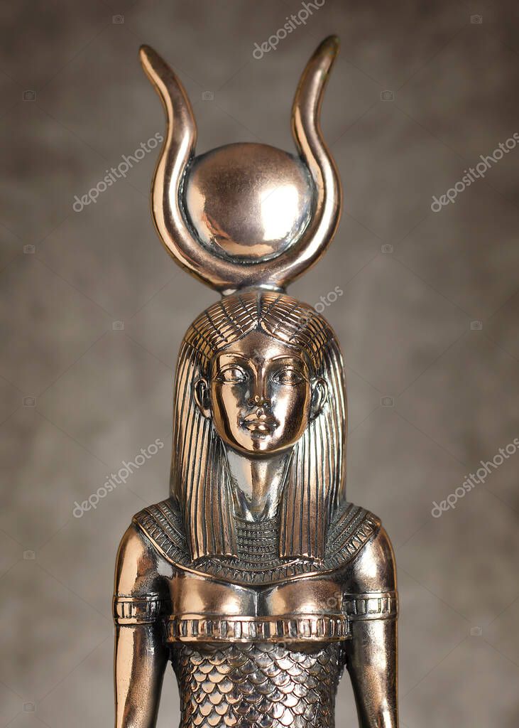 The figure of the Egyptian goddess Isis on a brown corduroy background ...