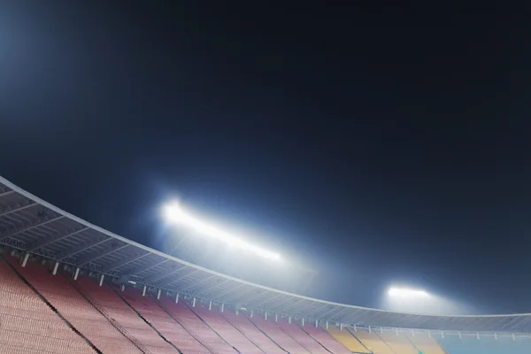 Blue tennis court view and stadium full of spectators with spotlights ...