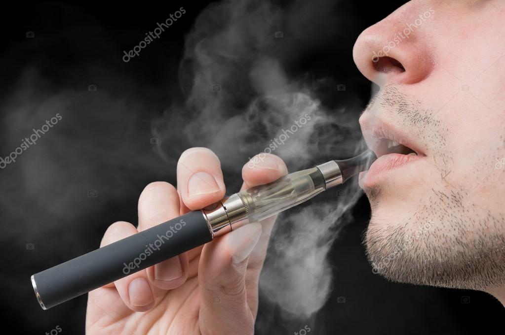 Man holds vaporizer or e-cigarette in hand and vaping. — Stock Photo ...